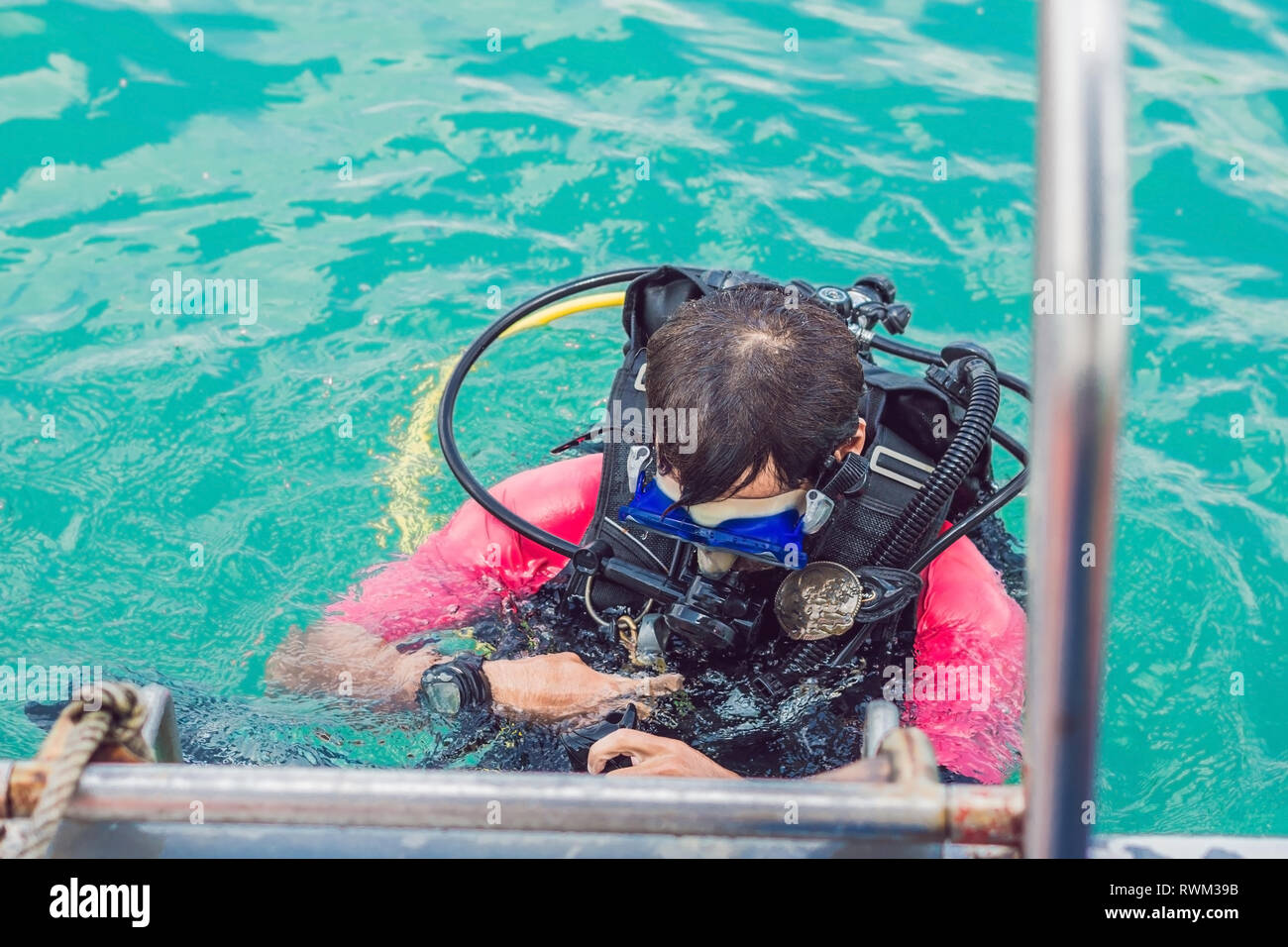 Happy diver returns to the ship after diving Stock Photo - Alamy