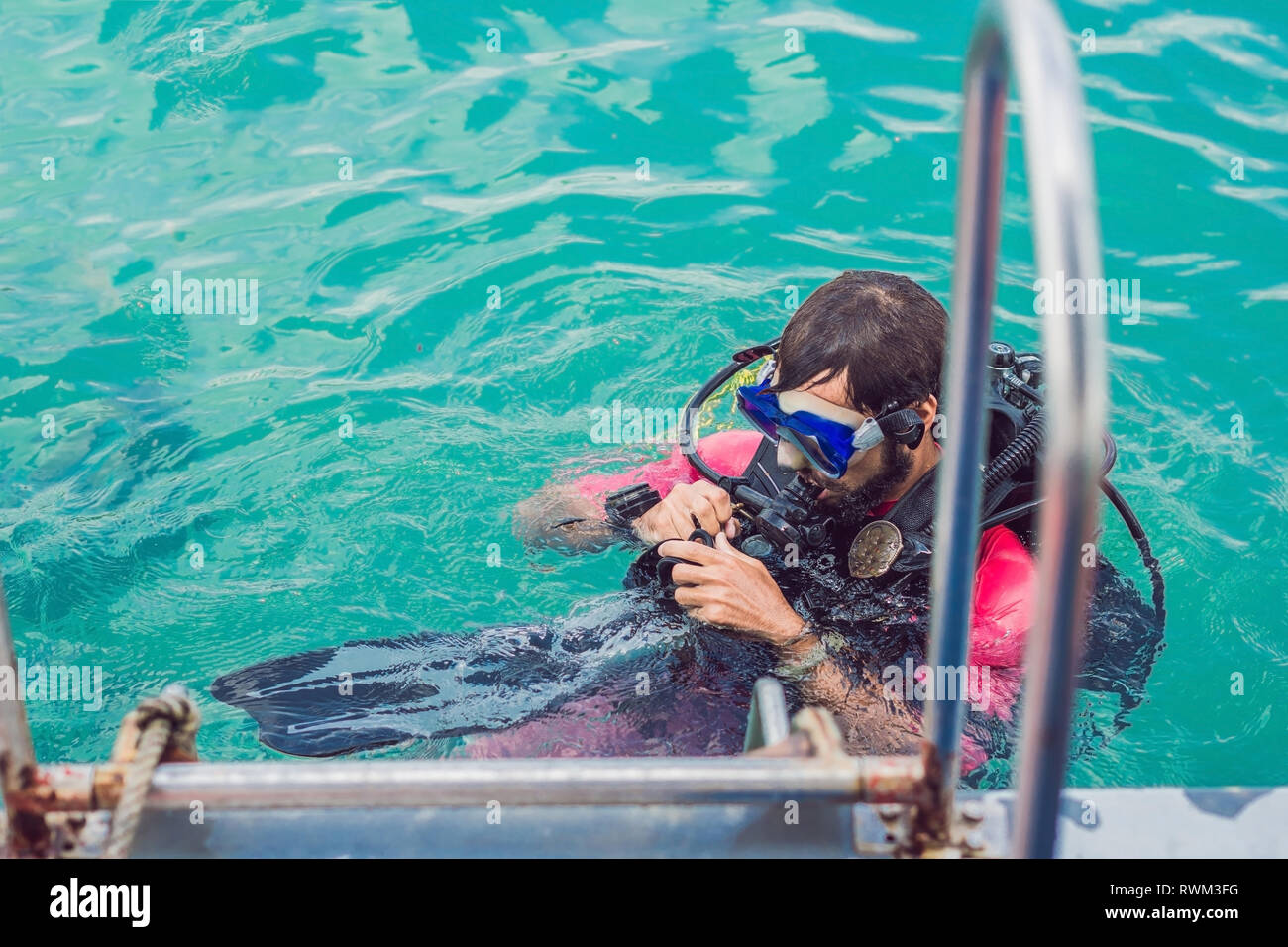 Happy diver returns to the ship after diving Stock Photo - Alamy