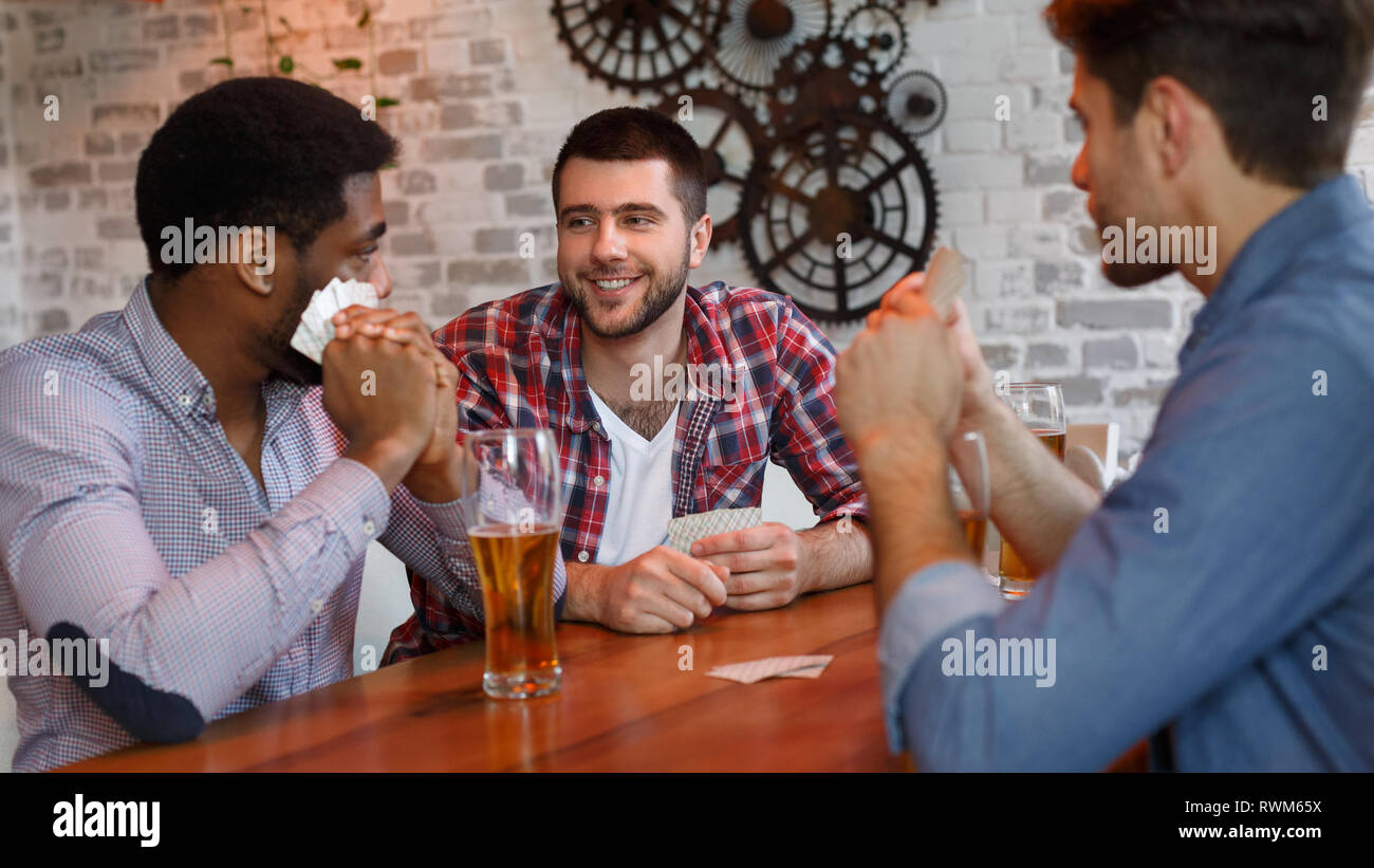 Best friends playing cards, having rest in bar Stock Photo - Alamy
