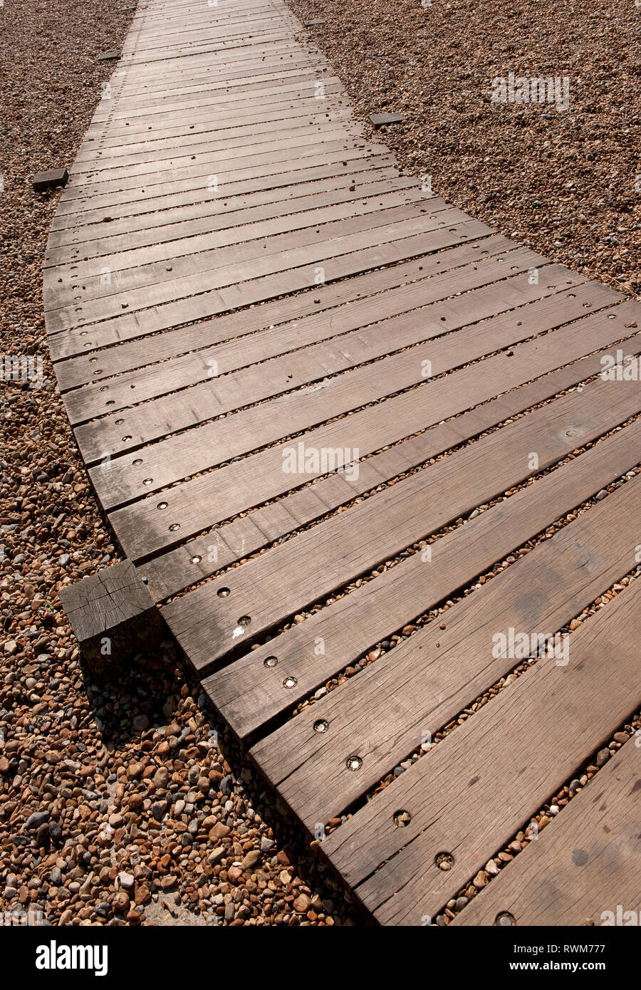 Path of wooden planks leading across a pebbled beach in the coastal ...