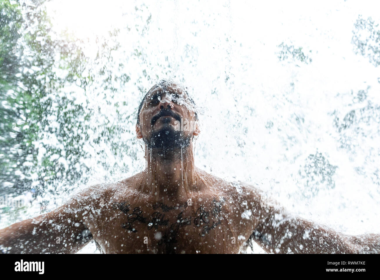 Man under refreshing waterfall Stock Photo - Alamy