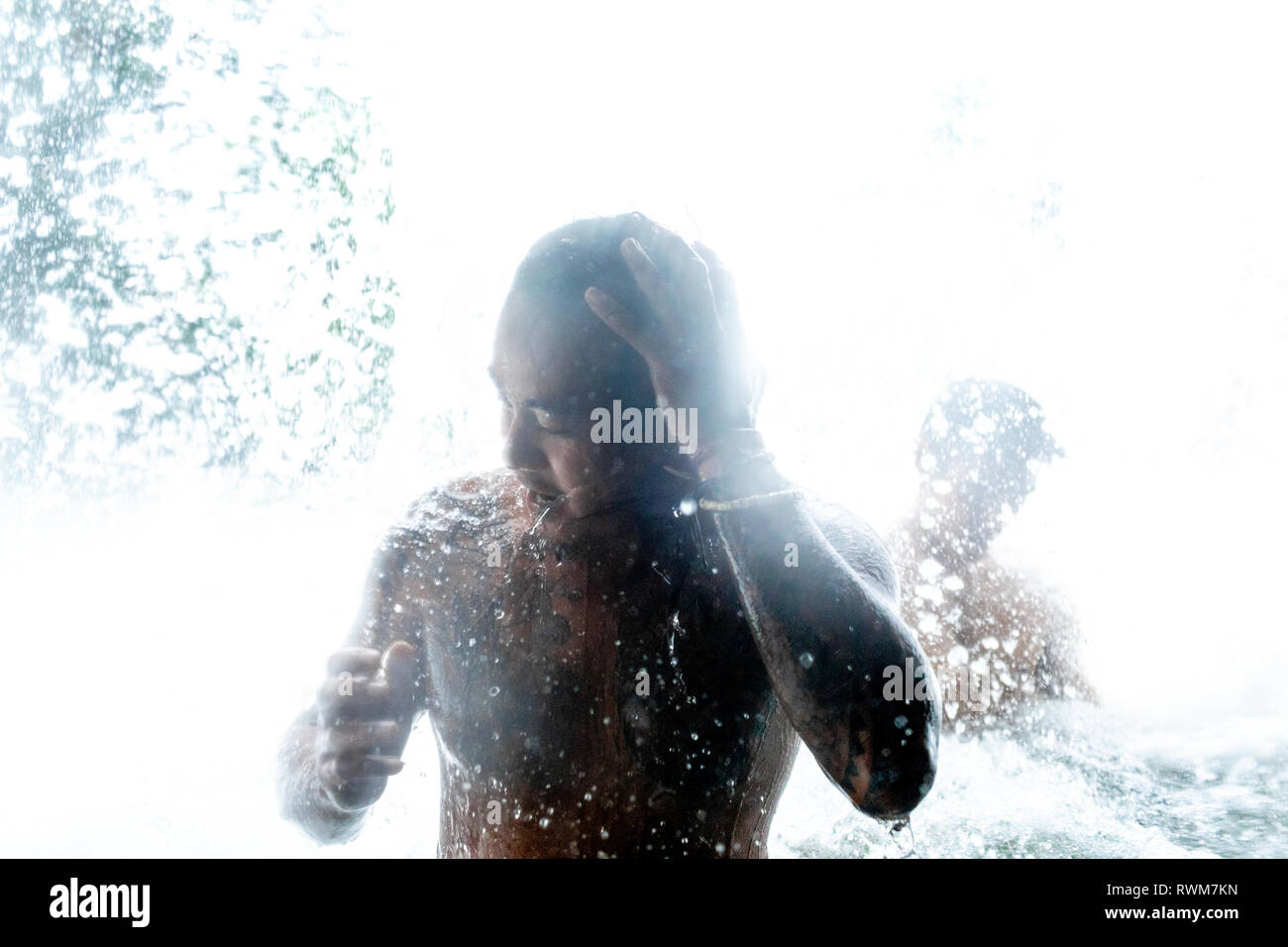 Men under refreshing waterfall Stock Photo - Alamy
