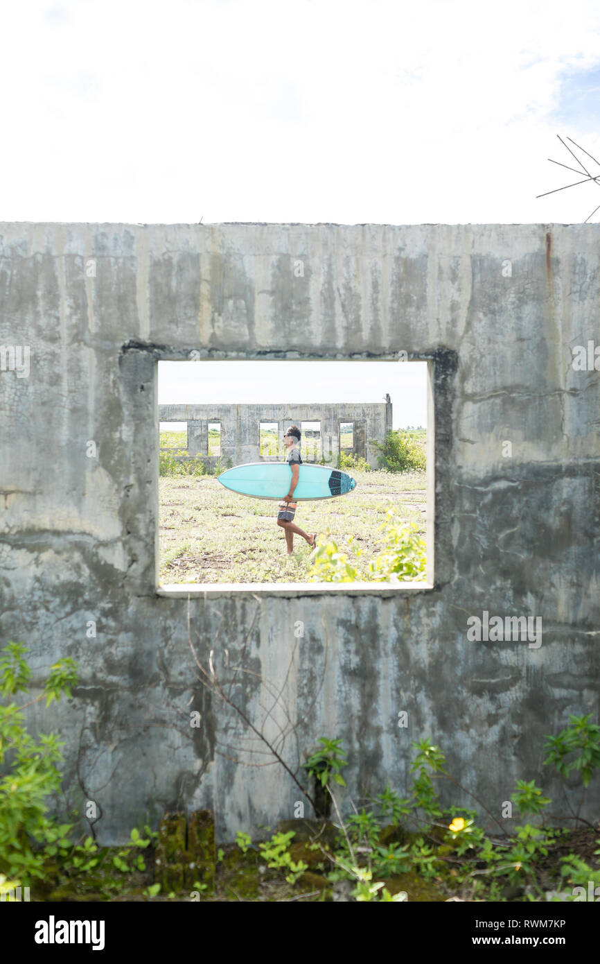 Surfer seen through window of abandoned building, Abulug, Cagayan ...