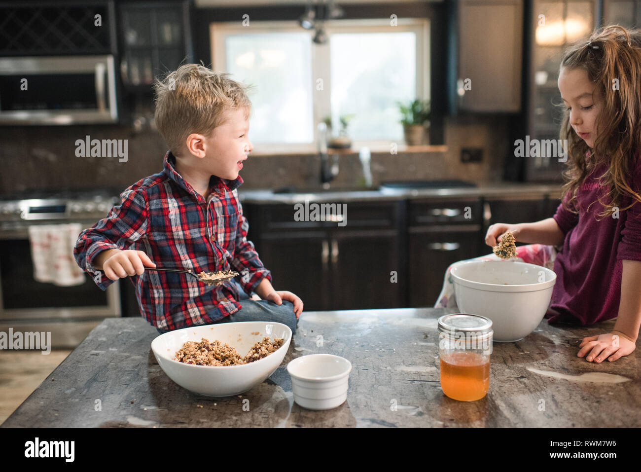 Children eating on kitchen worktop Stock Photo - Alamy