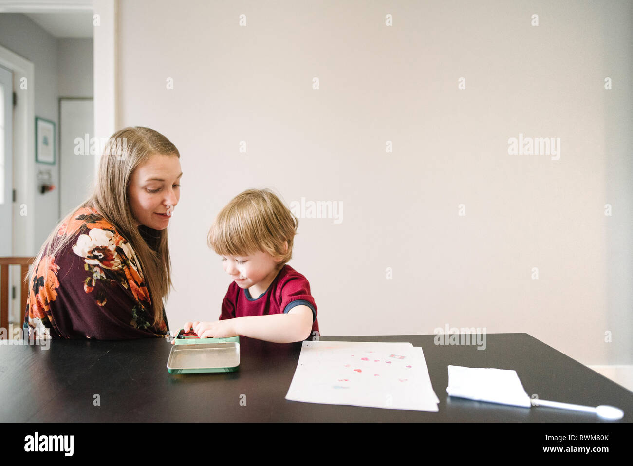 Mother watching over son learning at table Stock Photo - Alamy