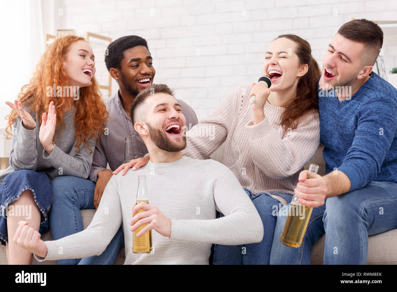 Happy friends singing songs, having fun together Stock Photo - Alamy