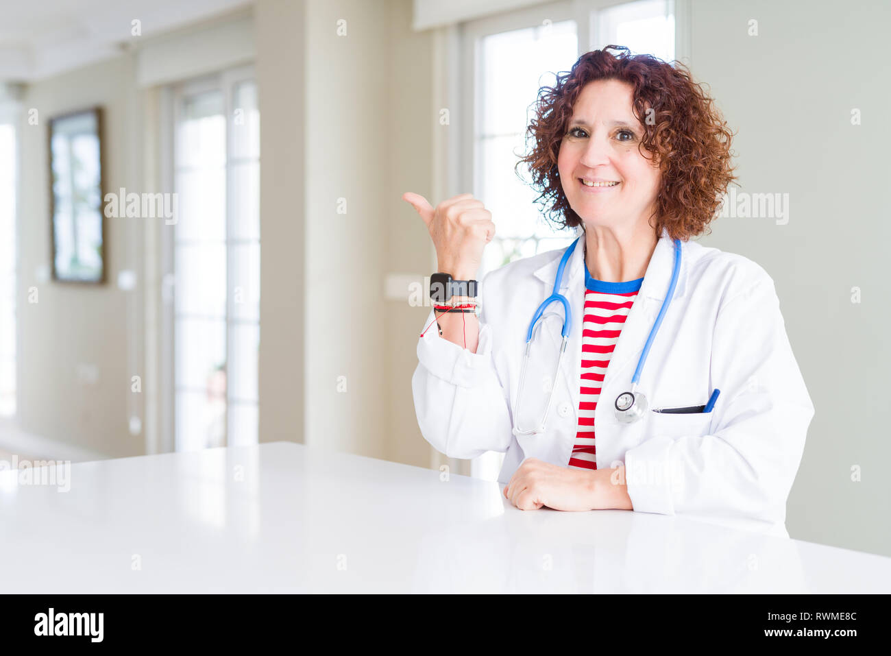 Senior doctor woman wearing medical robe at the clinic smiling with ...