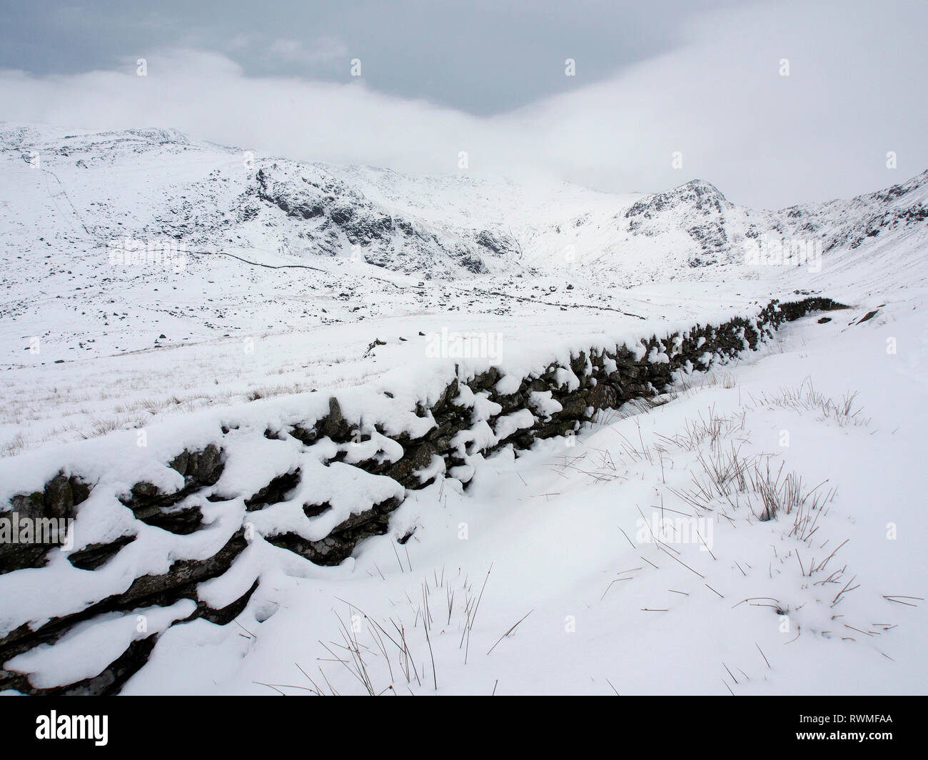 Dry stone wall near Ffynnon lugwy reservoir, Snowdonia, Wales in snow ...