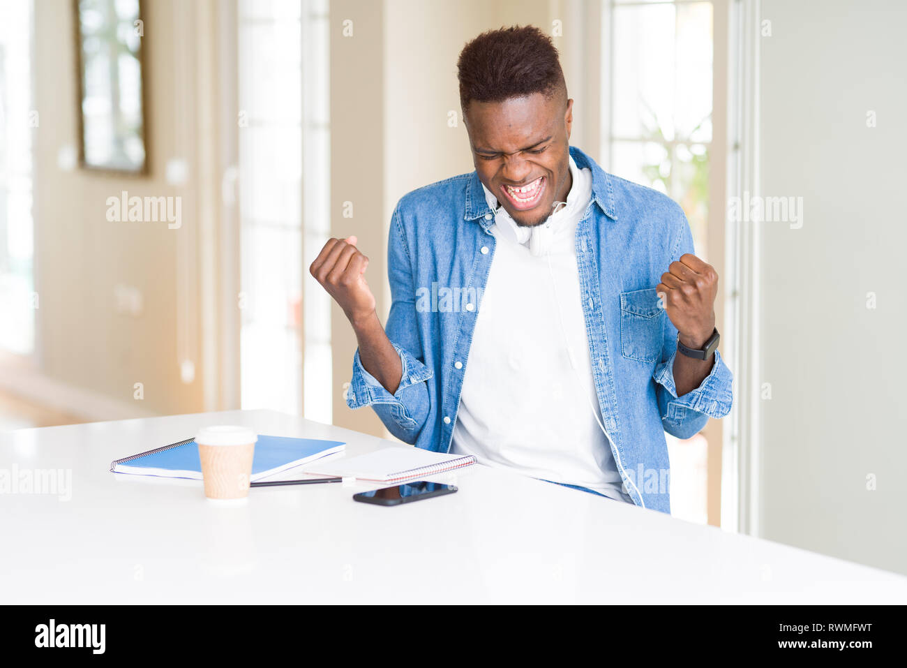 African american student man studying using notebooks and wearing ...