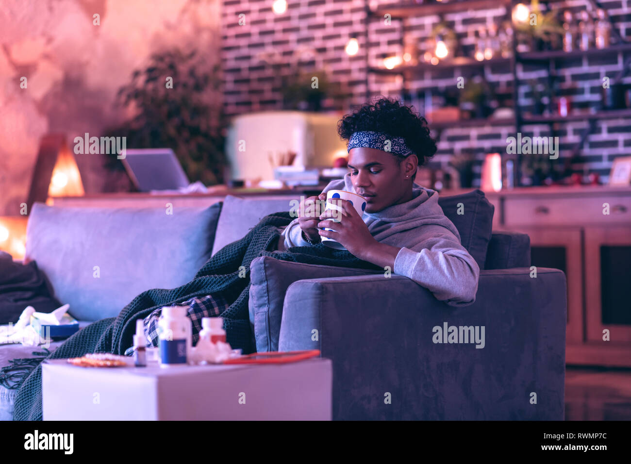 Adorable teen drinking tea prepared by mom and feeling himself better ...
