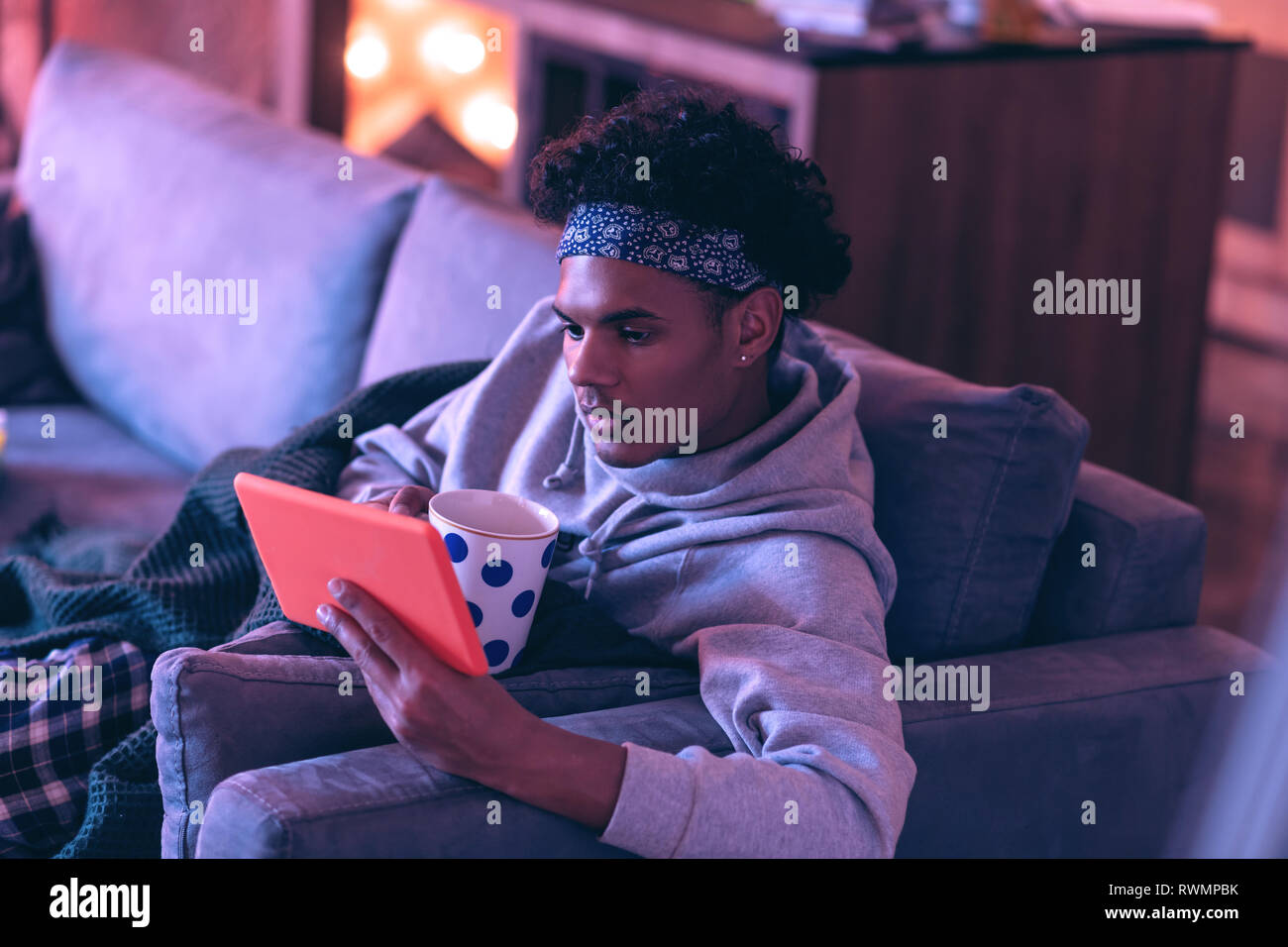 Pretty guy forgetting about cup and reading the message on the tablet ...