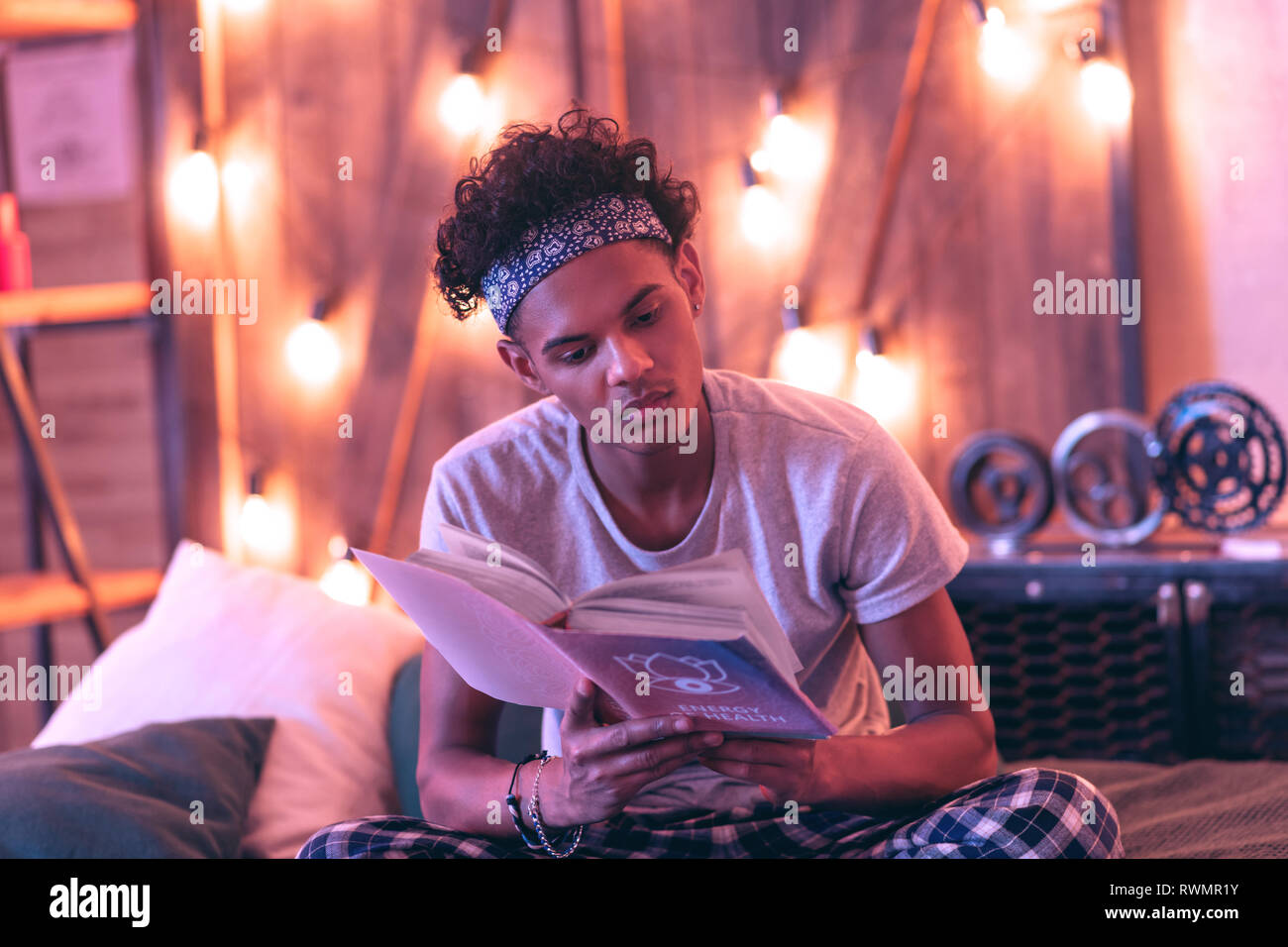 Curly young guy reading book hi-res stock photography and images - Alamy