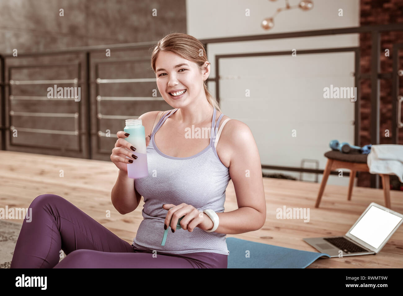 Resolute concentrated lady stretching her back while carrying foot ...