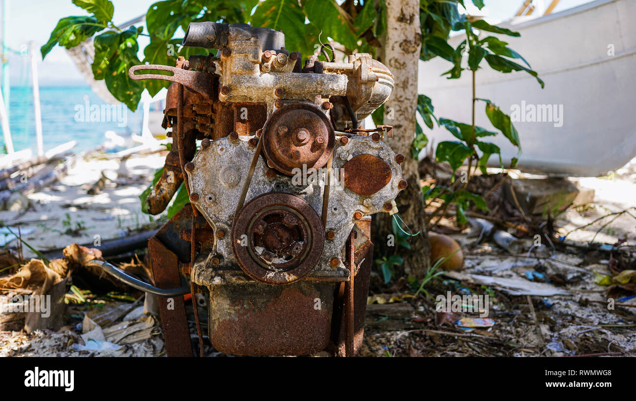 A rusty ship engine on a dirty strech of beach on Malapascua Island in ...