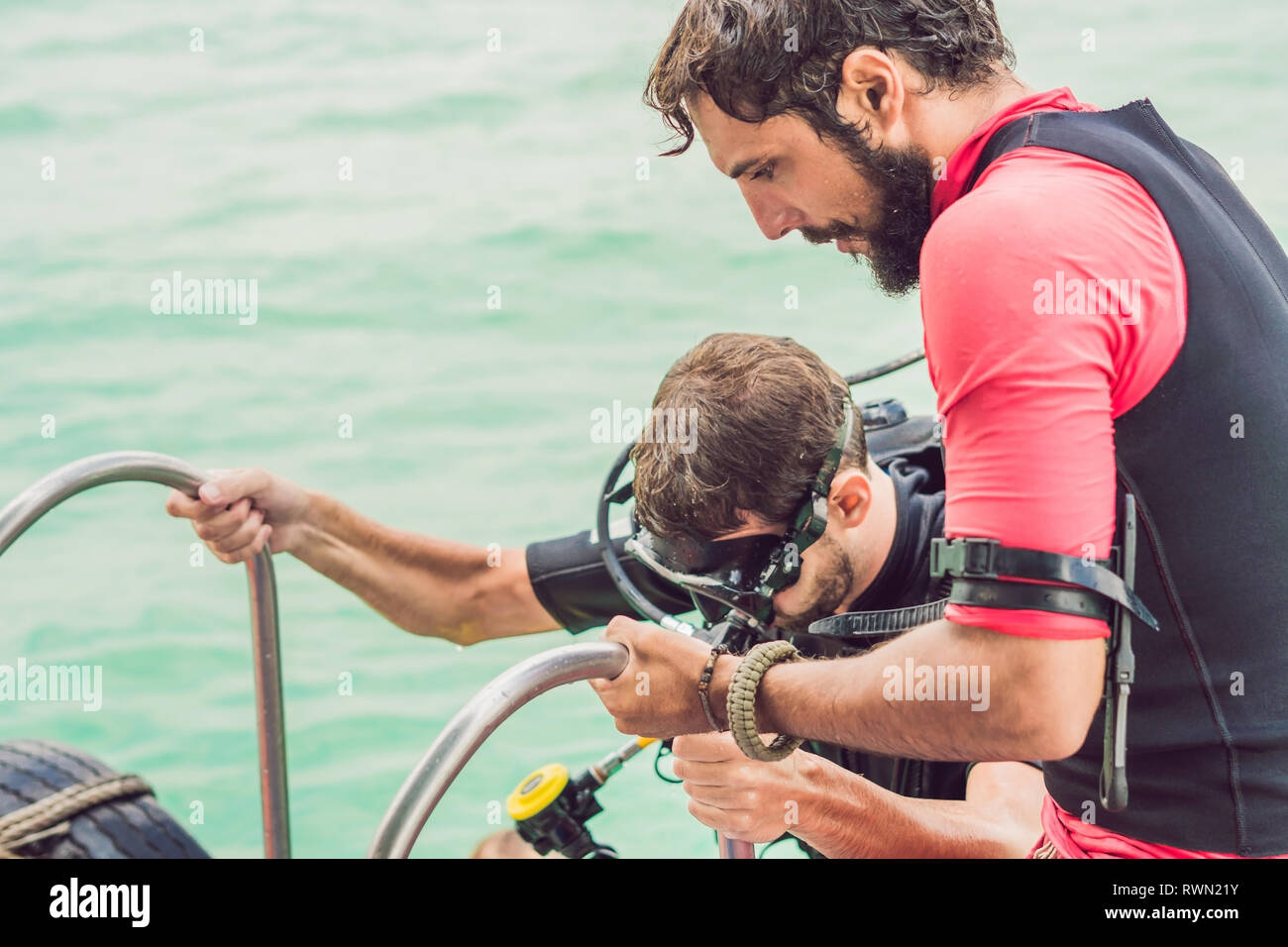 Happy diver returns to the ship after diving Stock Photo - Alamy