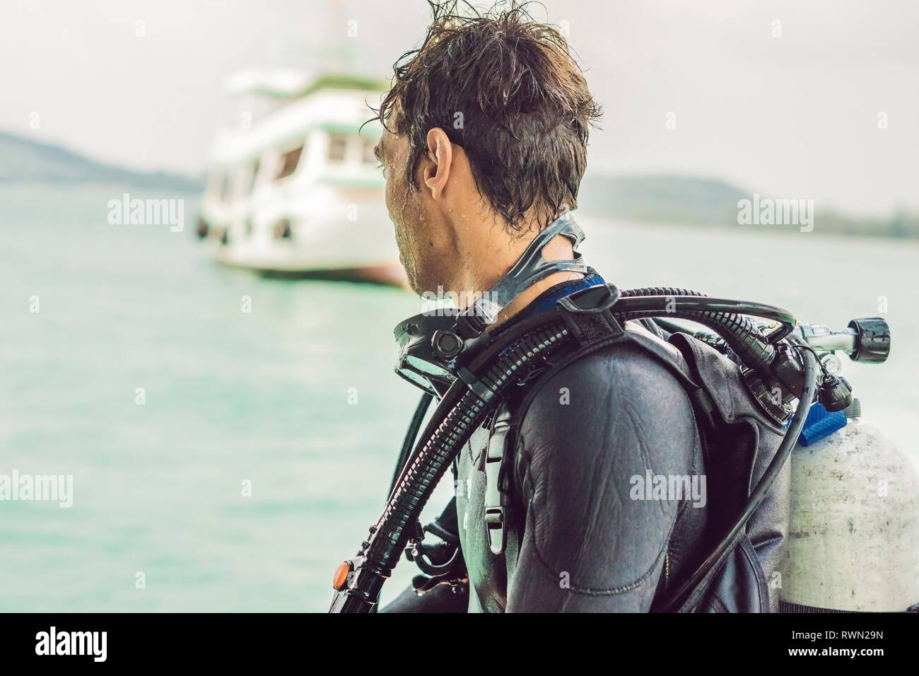 Happy diver returns to the ship after diving Stock Photo - Alamy