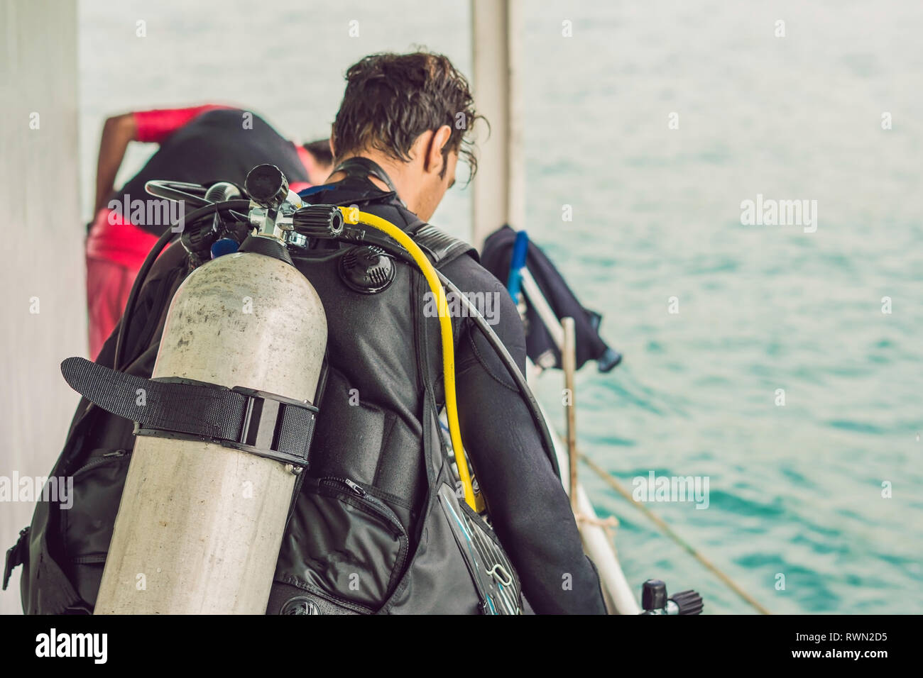 Happy diver returns to the ship after diving Stock Photo - Alamy