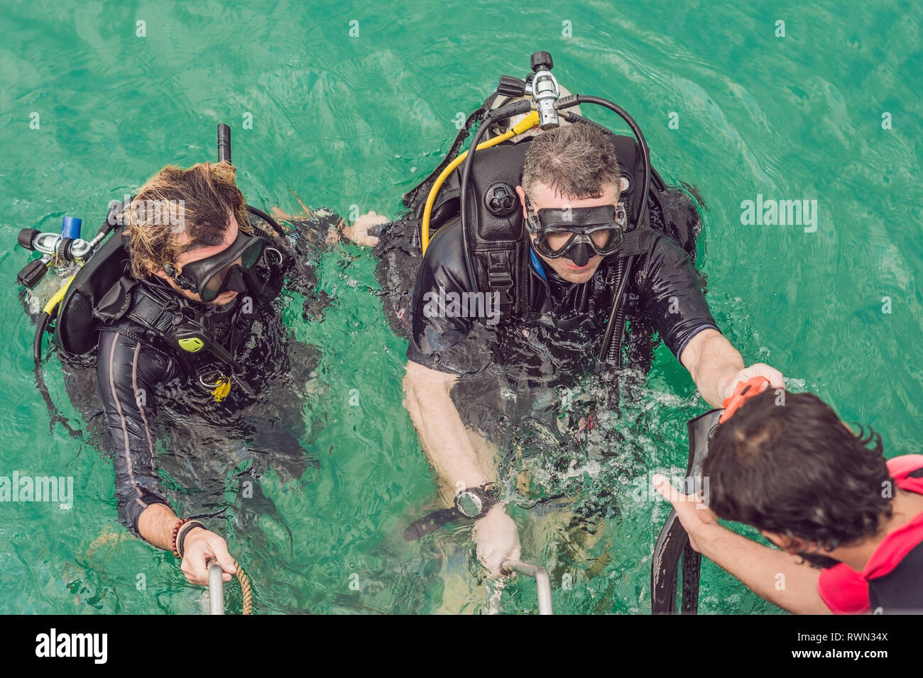 Happy diver returns to the ship after diving Stock Photo - Alamy