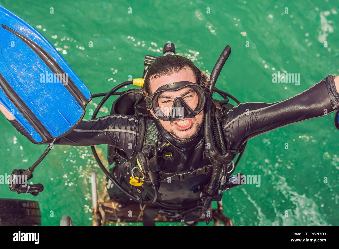 Happy diver returns to the ship after diving Stock Photo - Alamy