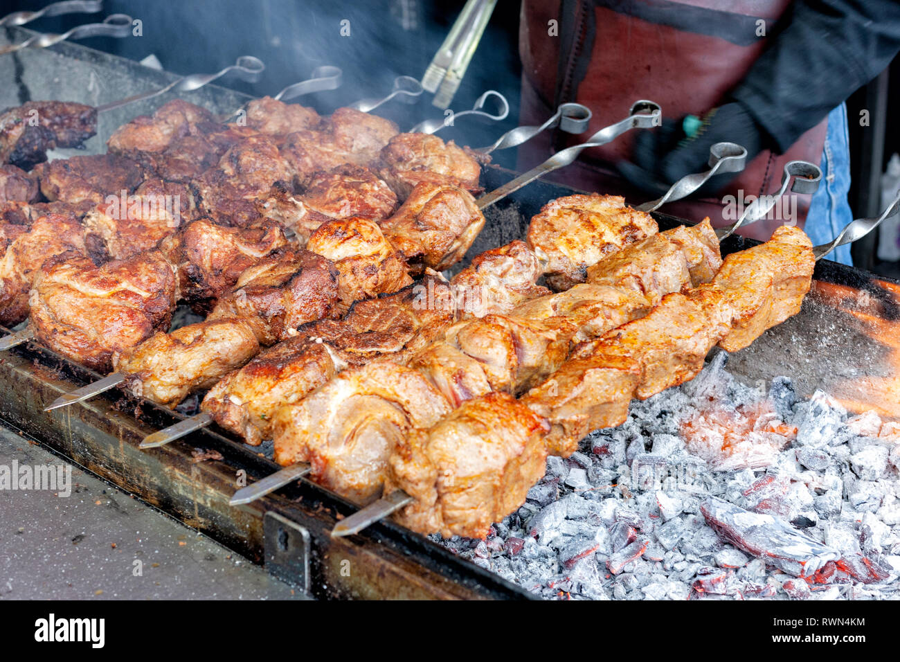grilled meat at street festival. huge pieces of meat cooking at ...