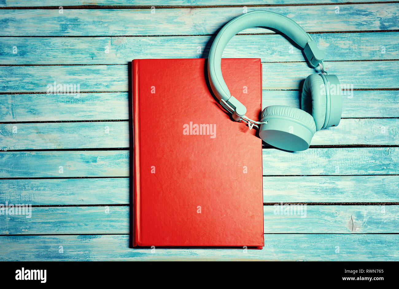 Headphones over books. Wooden Table. Reading and Audio books concept ...