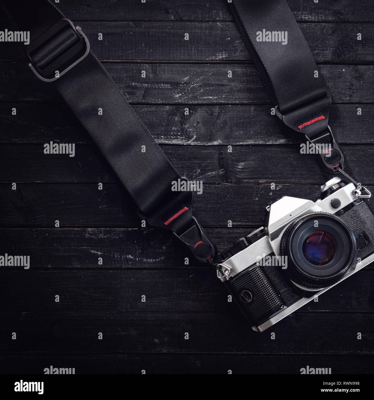 Classic camera on film with a strap. Wood black table background. Low ...