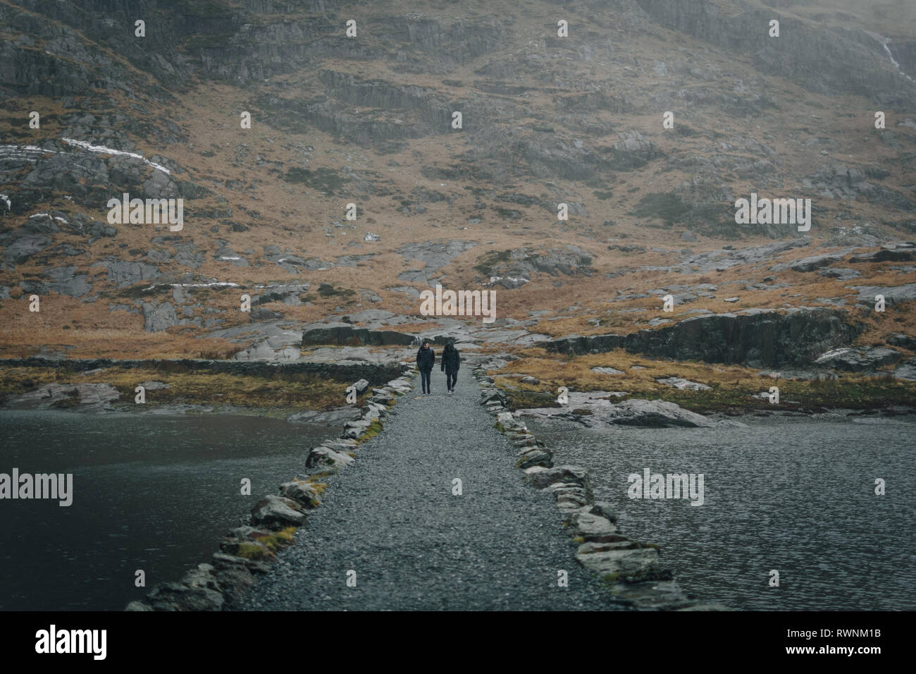 Two men crossing a footpath on Mount Snowdon in the rain Stock Photo ...