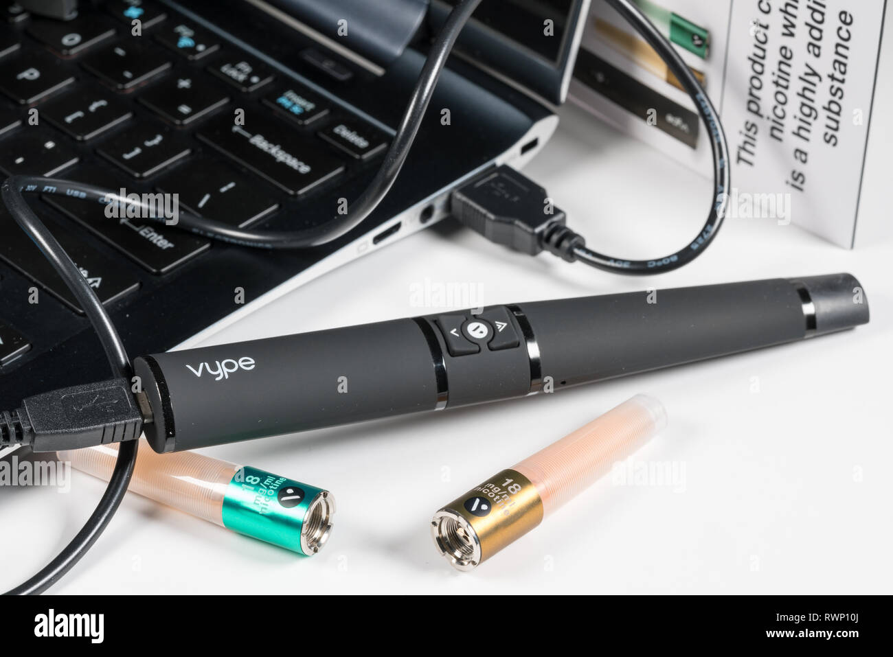 Vype ePen nicotine dispenser being charged with flavour caps Stock ...