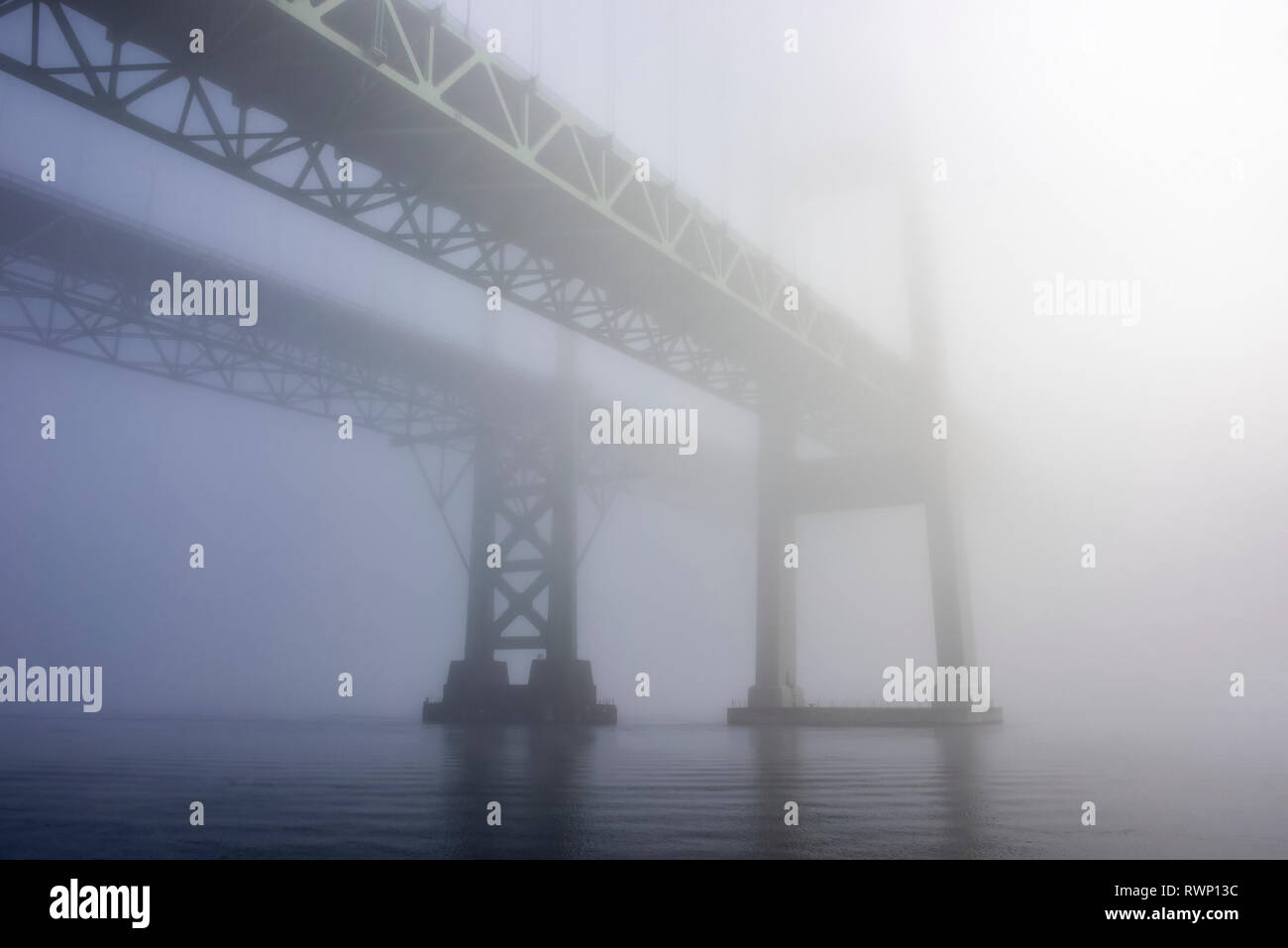 The Tacoma Narrows Bridges in the fog from the water surface. The ...