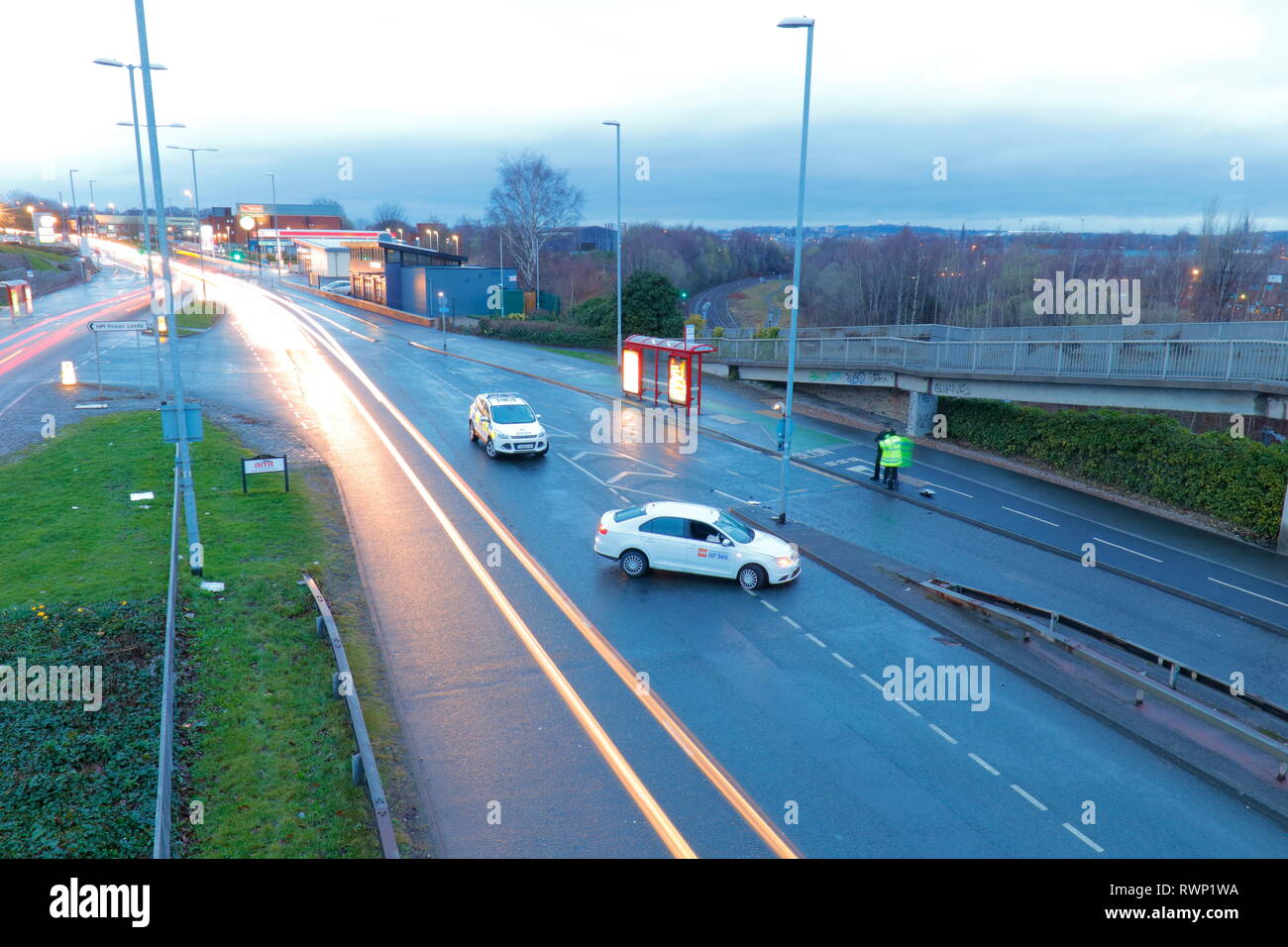A private hire vehicle sits on a dual carriageway in Leeds, guarded by ...