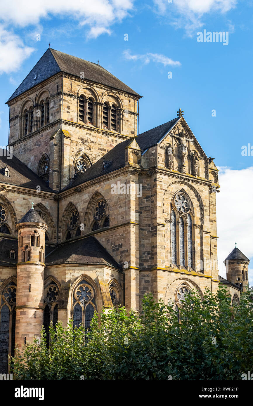 Back side of a large stone church with arched stained glass windows and ...