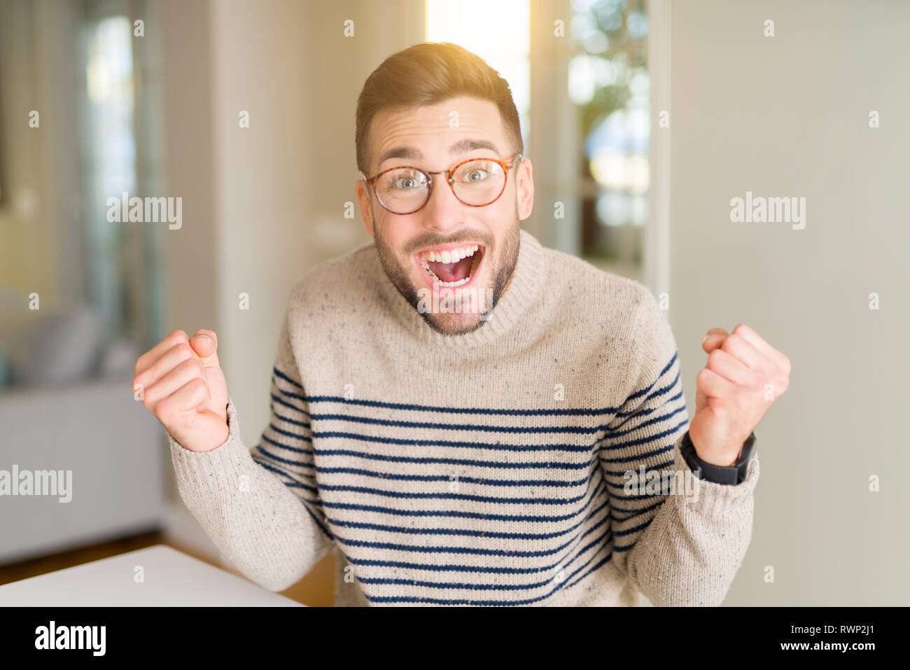 Young Handsome Man Wearing Glasses At Home Celebrating Surprised And