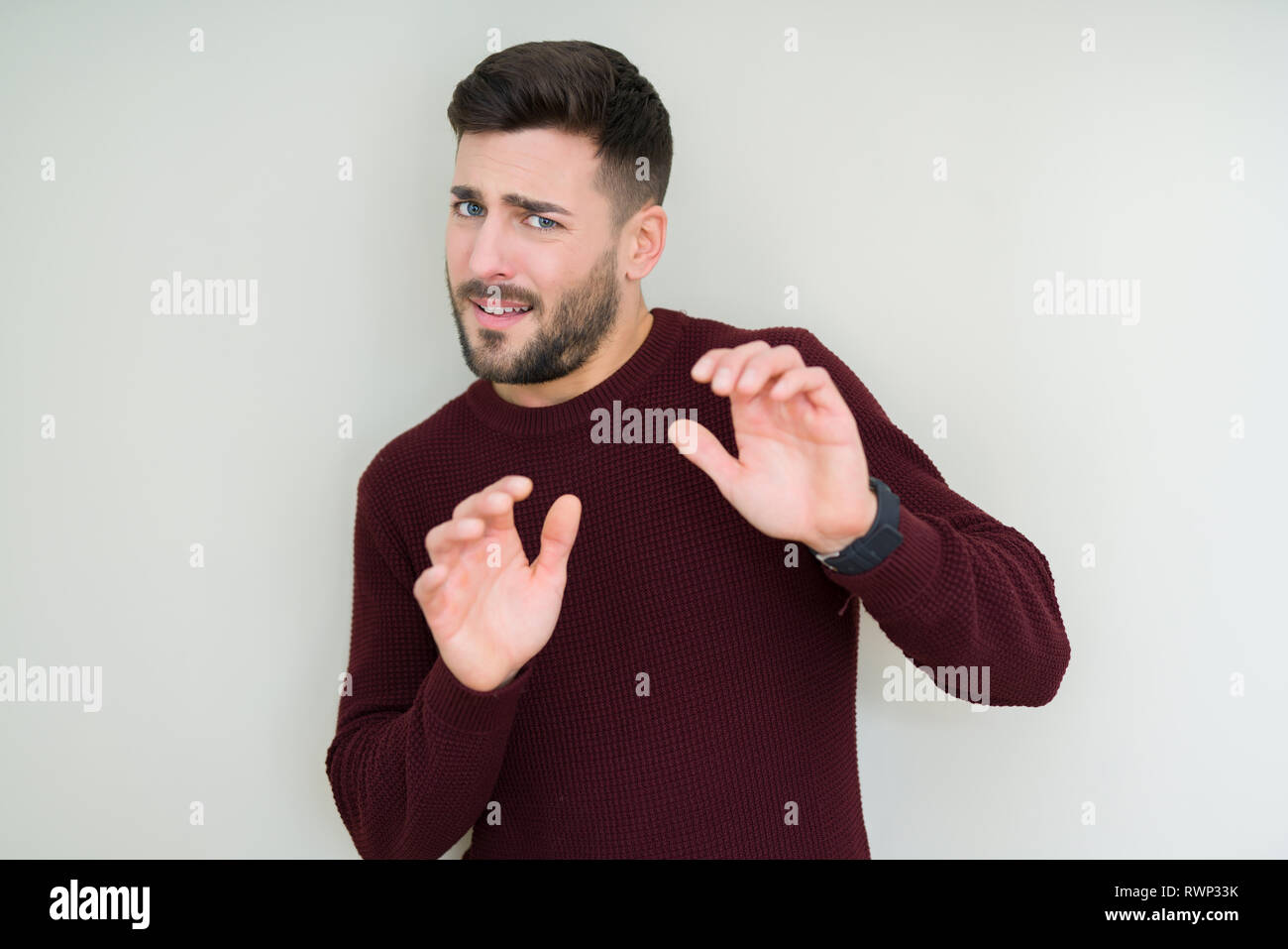 Young handsome man wearing a sweater over isolated background disgusted ...