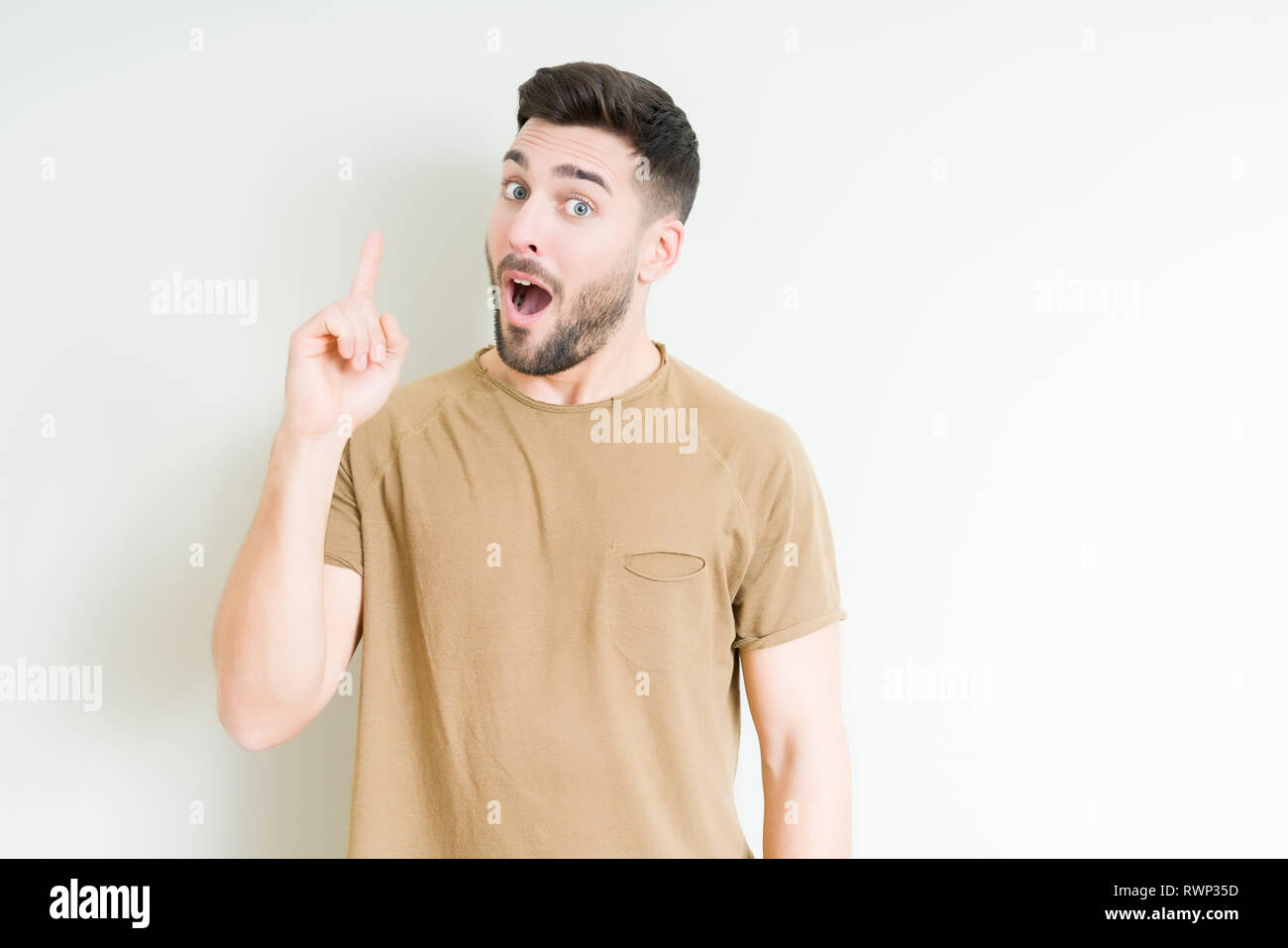 Young handsome man over isolated background pointing finger up with ...
