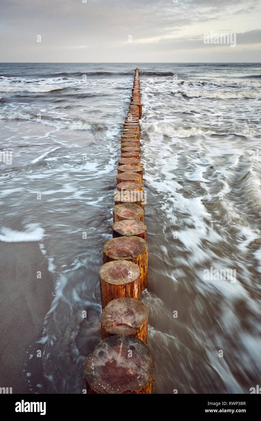 Wooden sea breakwater at sunrise, long exposure picture Stock Photo - Alamy