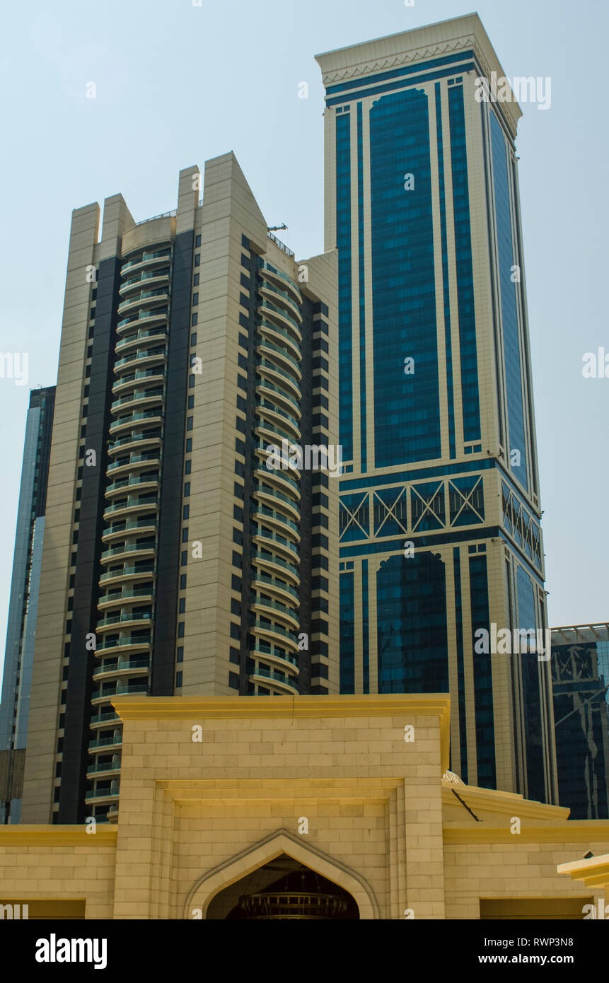 Modern skyscrapers with brick building in the foreground; Doha, Qatar ...