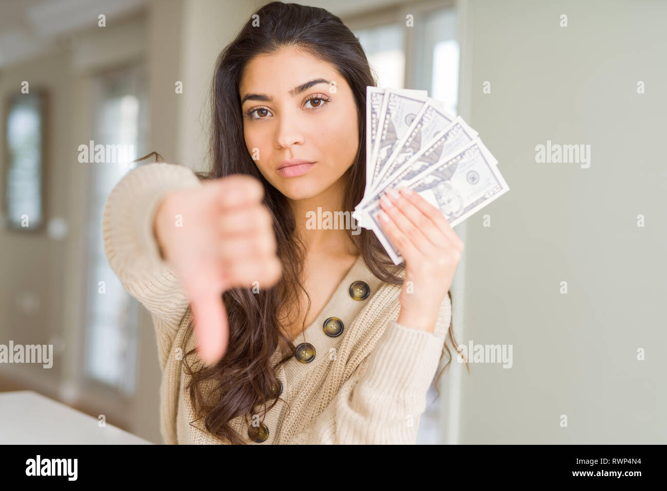 Young woman holding 50 dollars bank notes with angry face, negative ...
