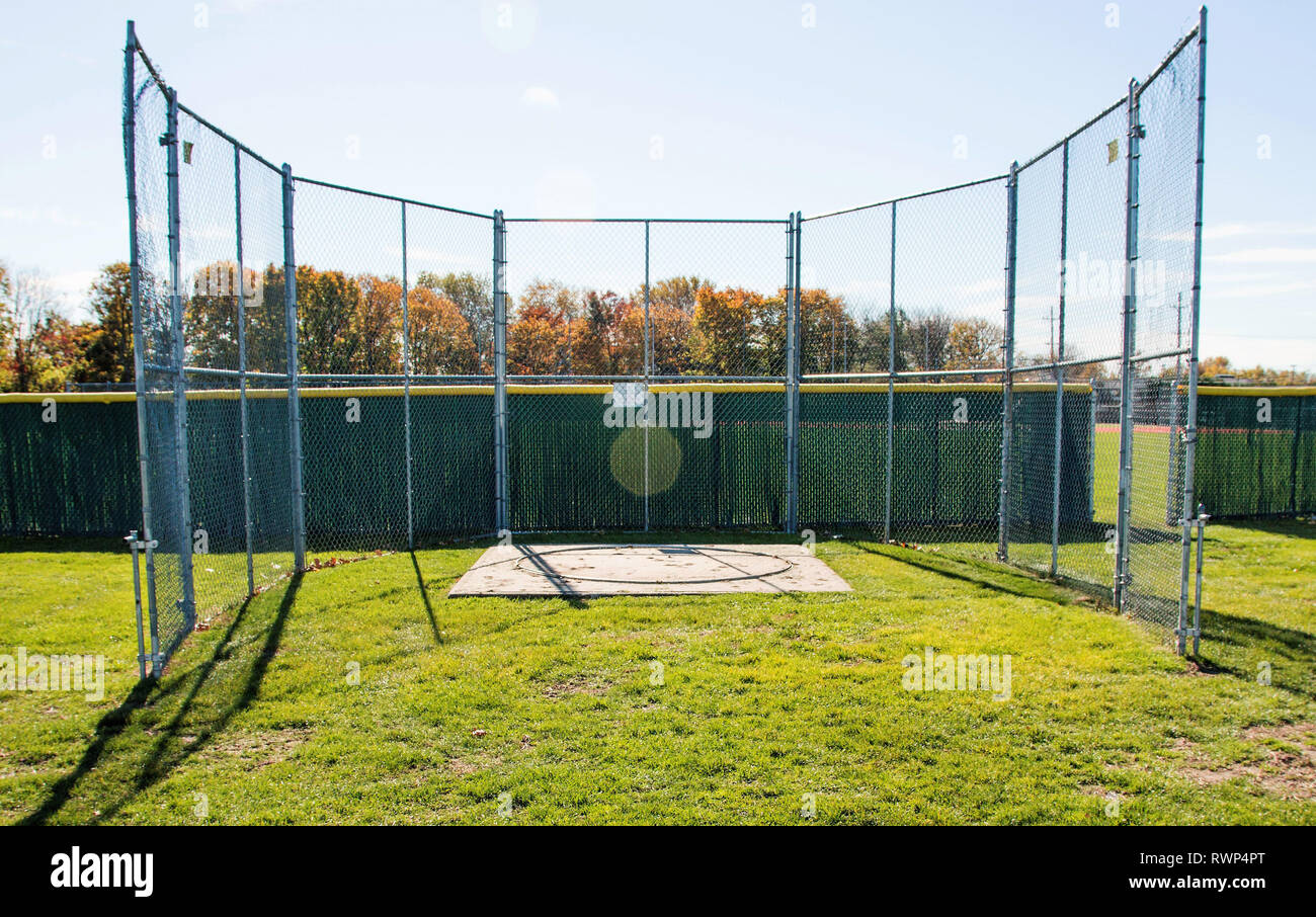 Fenced in discus cage for high school athletics Stock Photo - Alamy