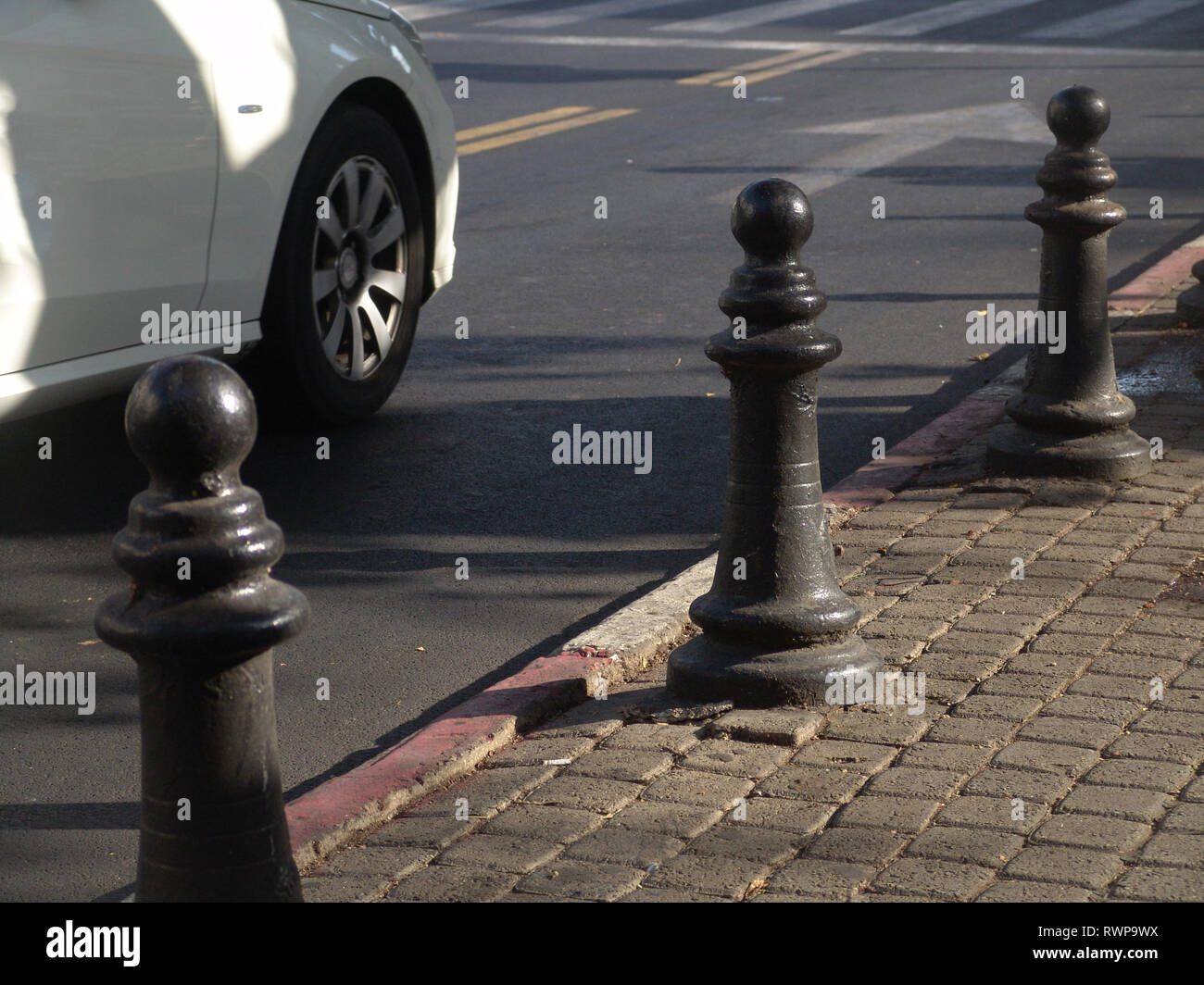 Urban street view of a white car driving on the road with a diagonal ...