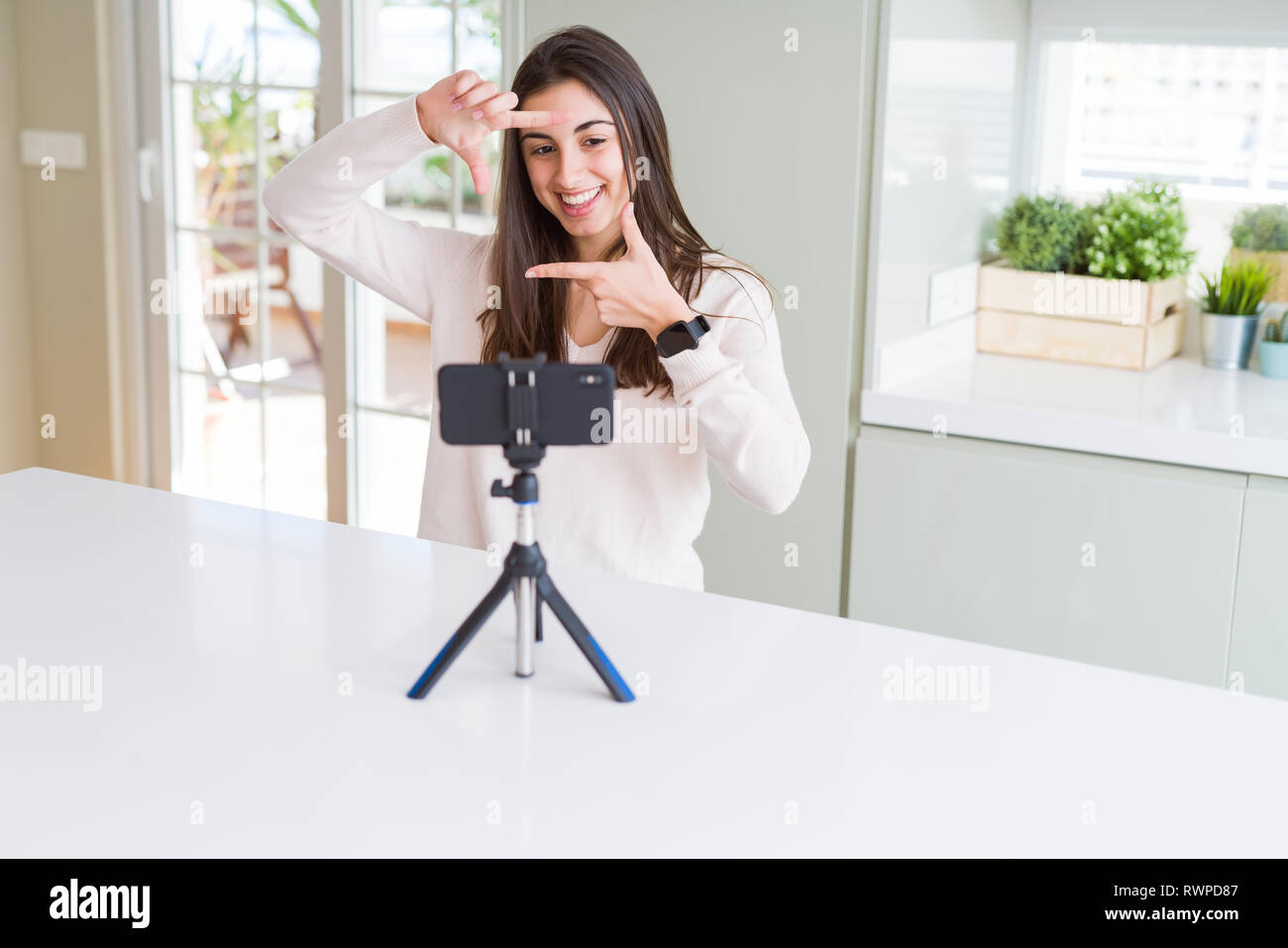 Beautiful young woman recording selfie video with smartphone webcam ...