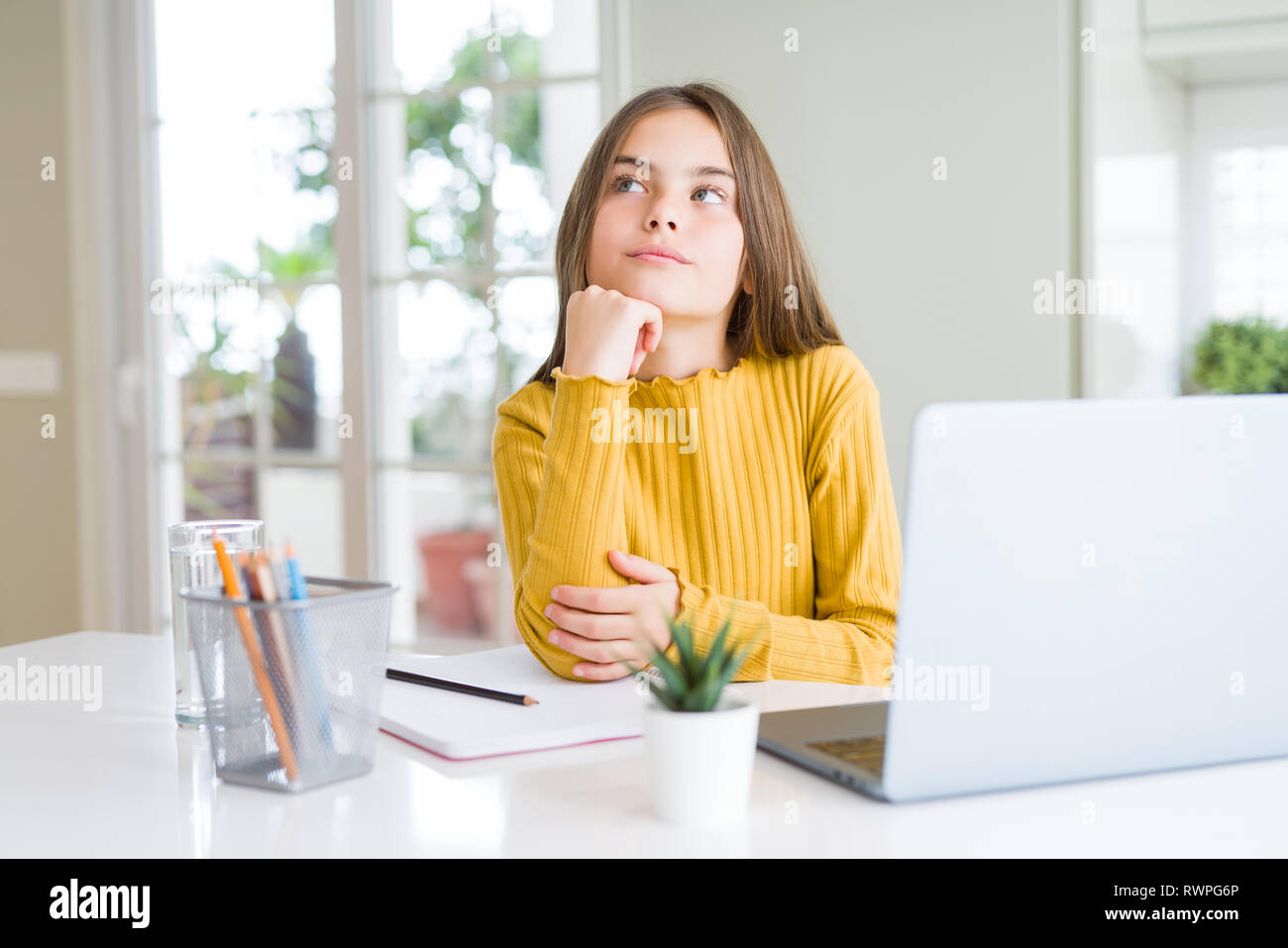 Beautiful young girl studying for school using computer laptop serious ...