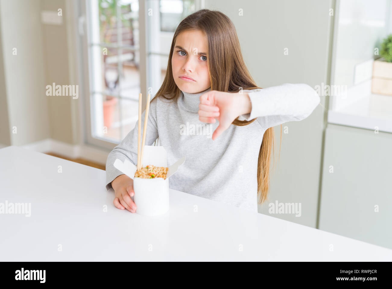 Beautiful young girl kid eating asian rice in delivery box with angry ...