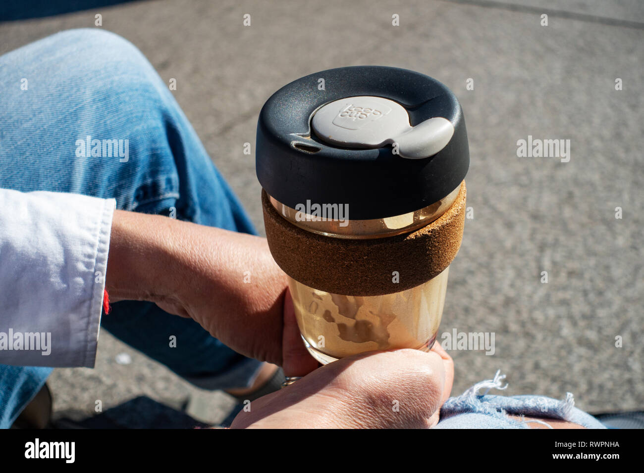 closeup of a young girl hands and wearing ripped jeans holding her ...