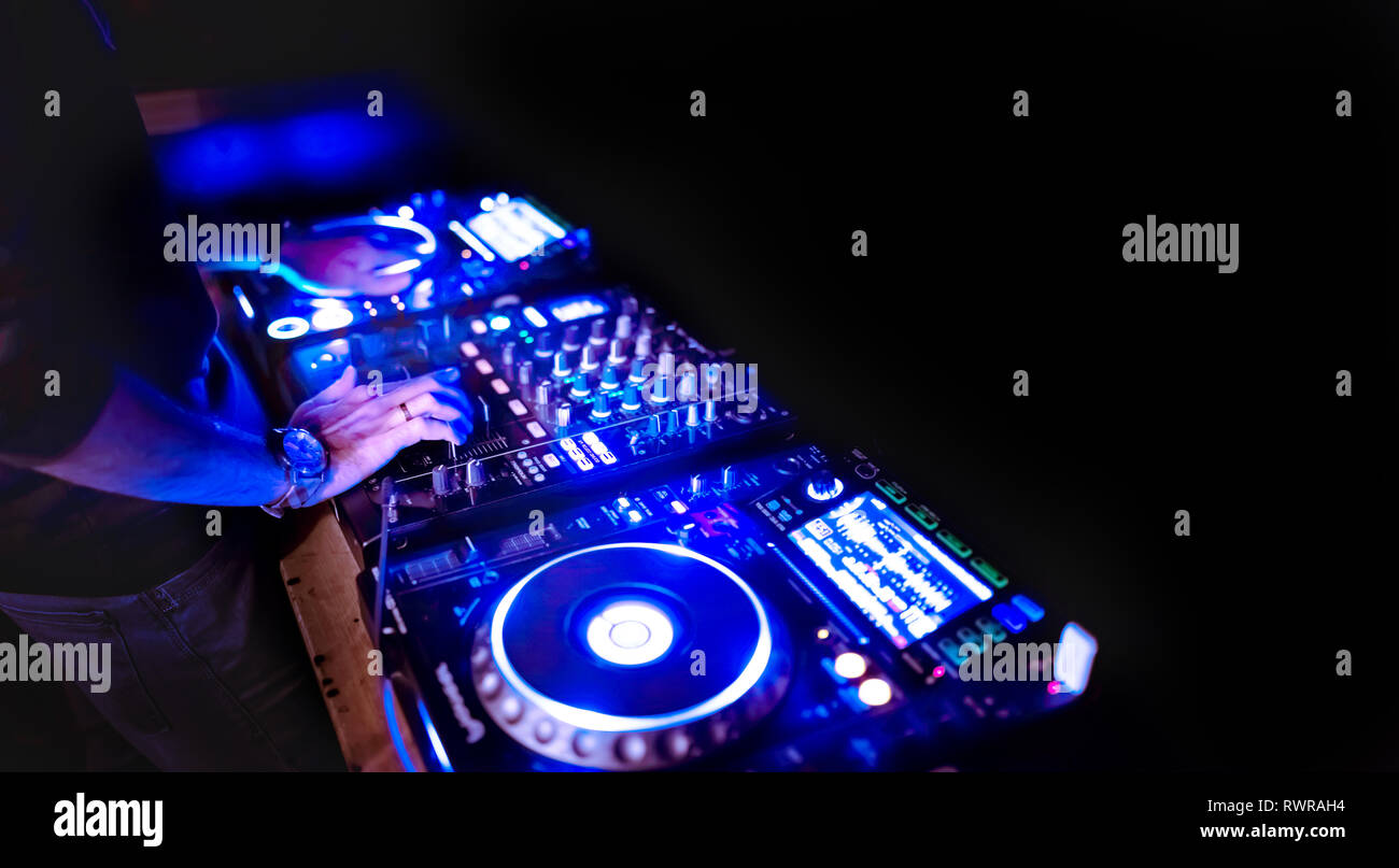Soft view of man hand disc jockey mixing and blending music tracks on ...