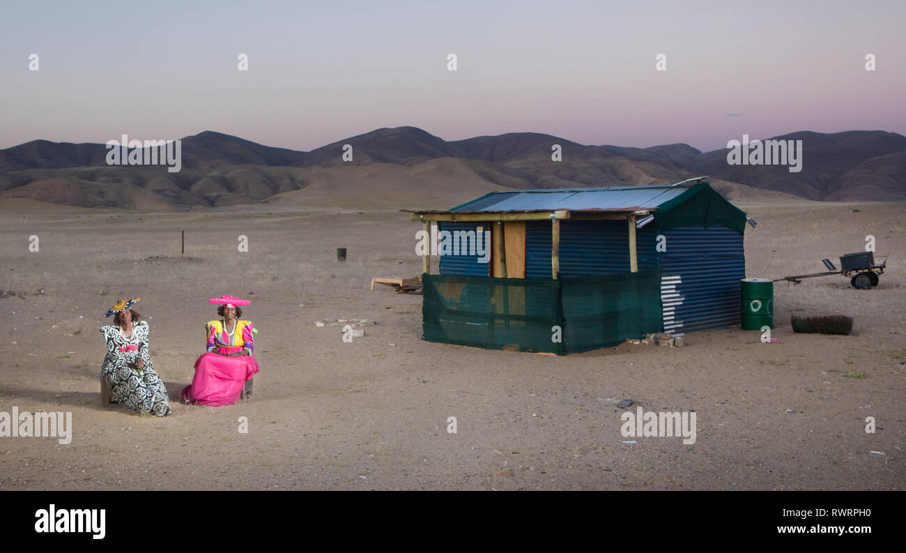 Herero women sit outside a house in Purros, Kunene Region, Namibia ...