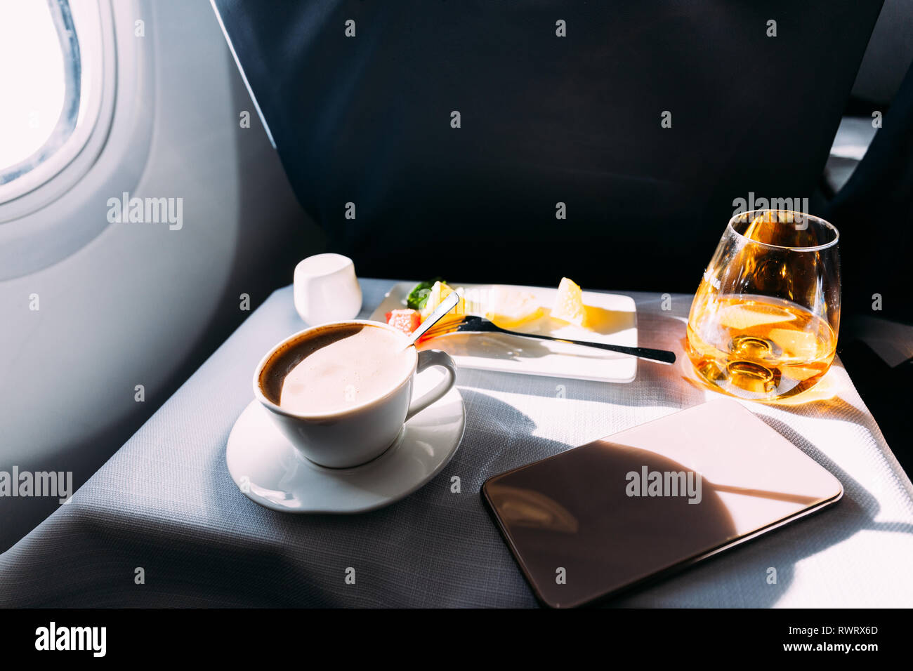 passenger table in airplane with drinks, snacks and digital tablet with ...