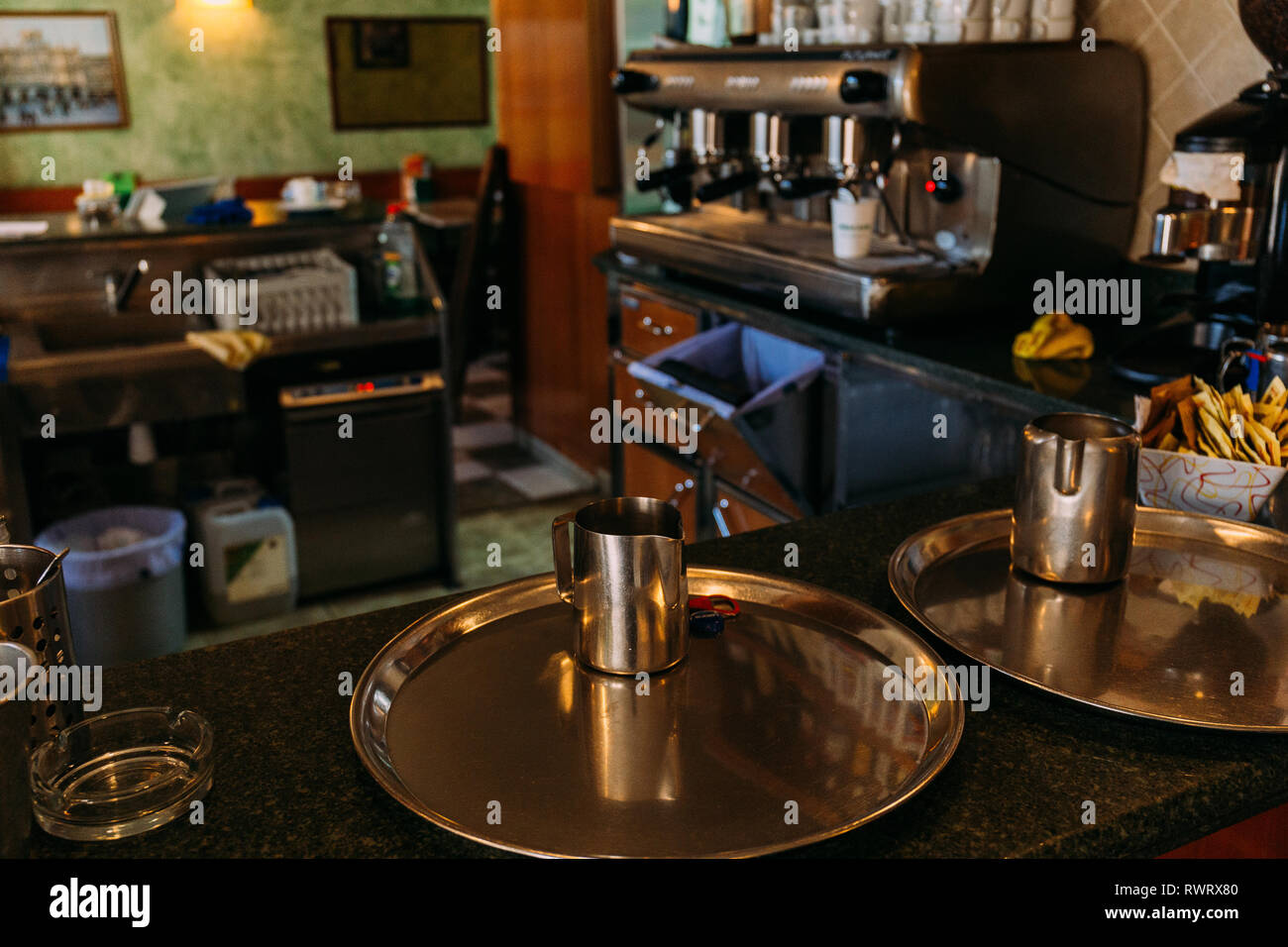 selective focus of metallic round trays and cups on bar counter in cafe ...
