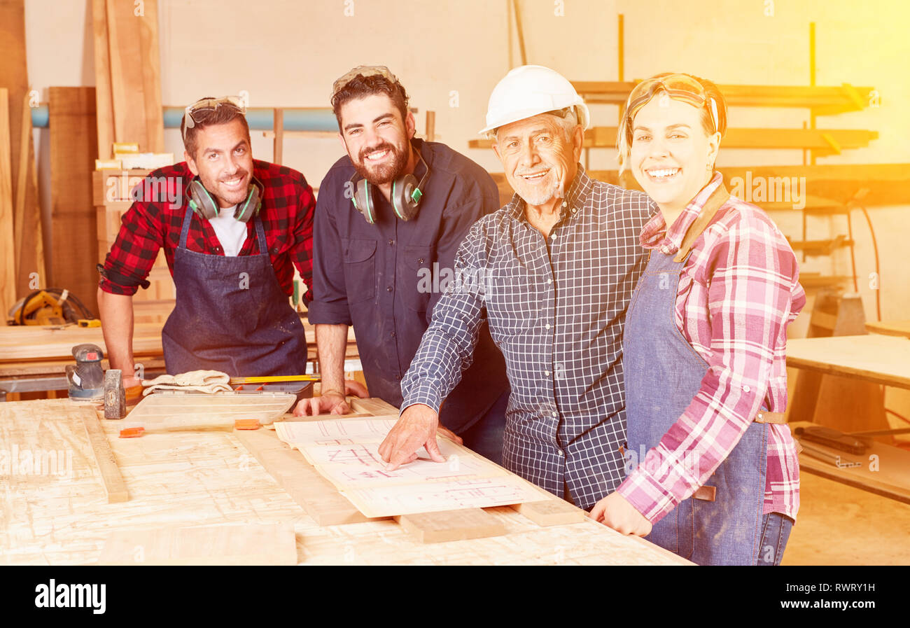 Group of craftsmen with blueprint in the workshop of a joinery Stock ...