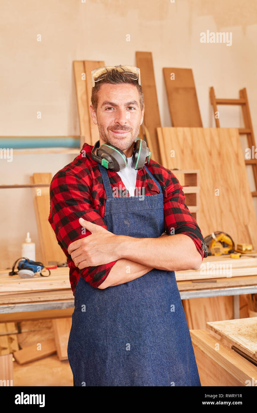 Man as a satisfied carpenter with crossed arms in his workshop Stock ...