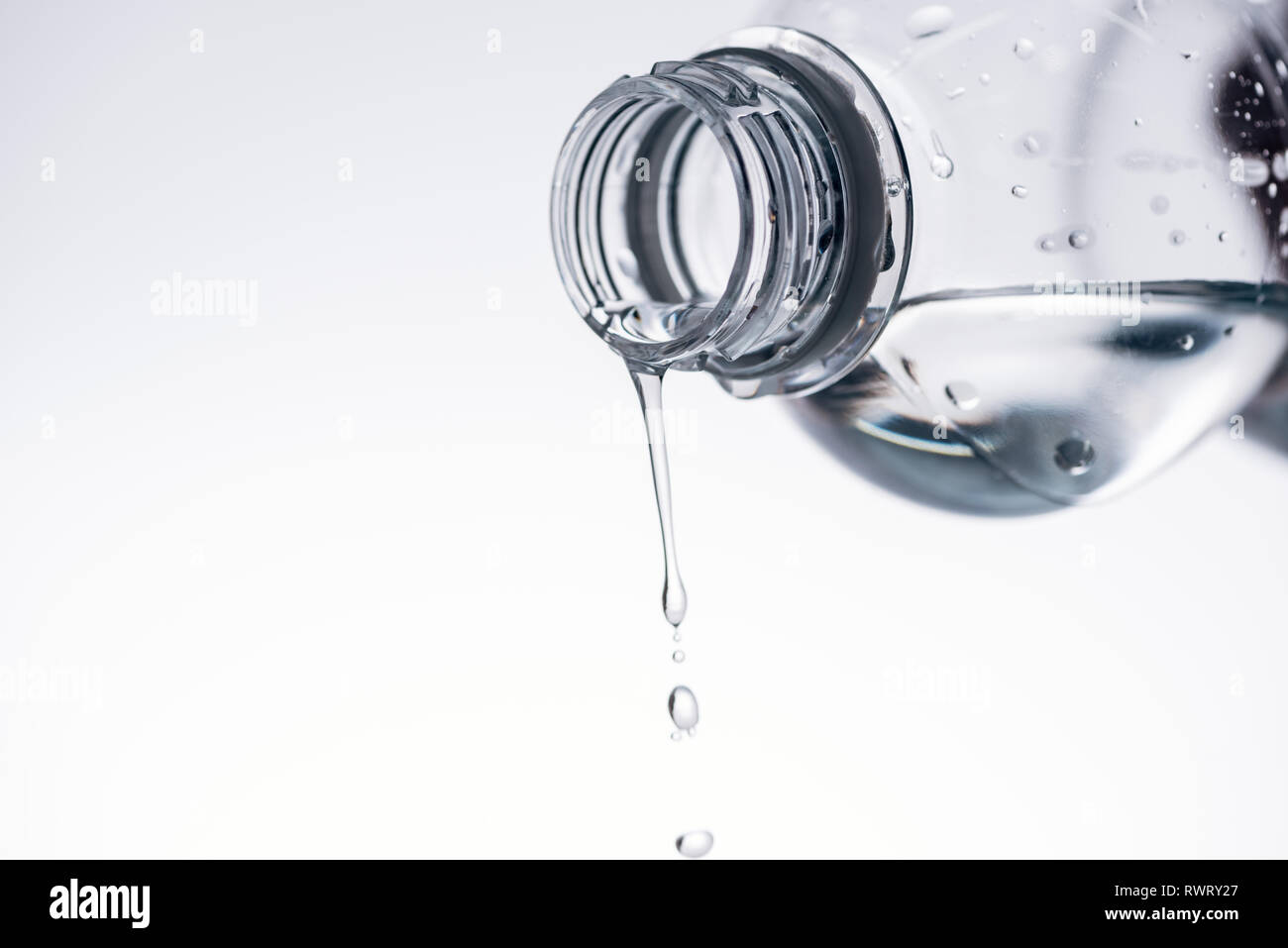 water dripping from plastic bottle isolated on white with copy space ...